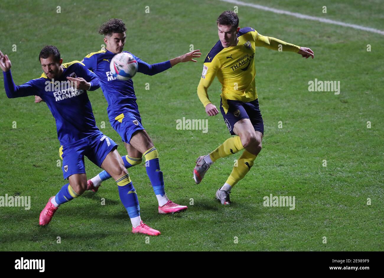 Oxford United's Josh Ruffels (right) gets his cross past AFC Wimbledon ...