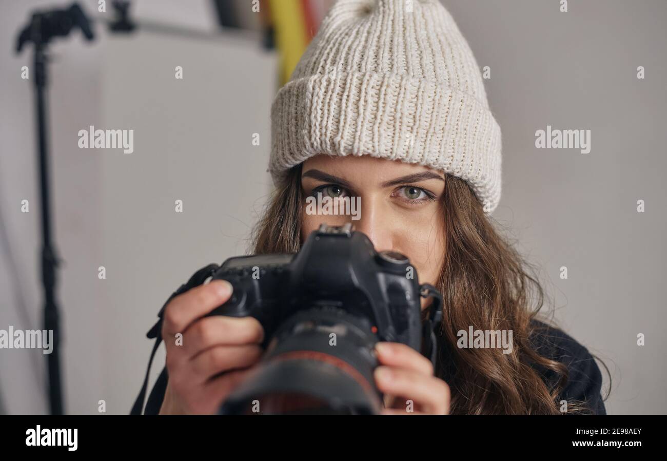 Close up photo of woman in hat on studio background taking a photo with ...