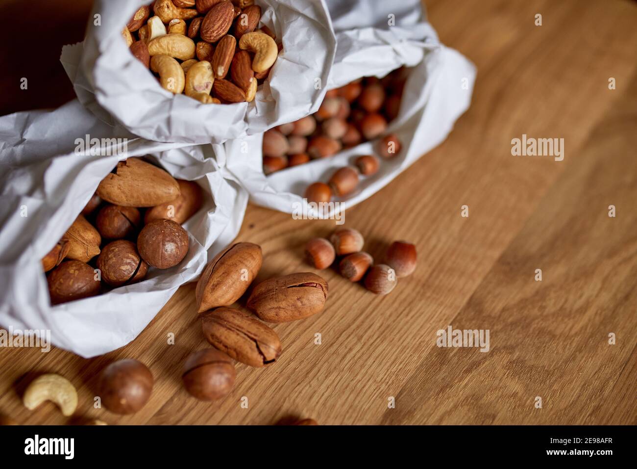 Top view Various sort of nuts on the table in a paper bag on wooden ...