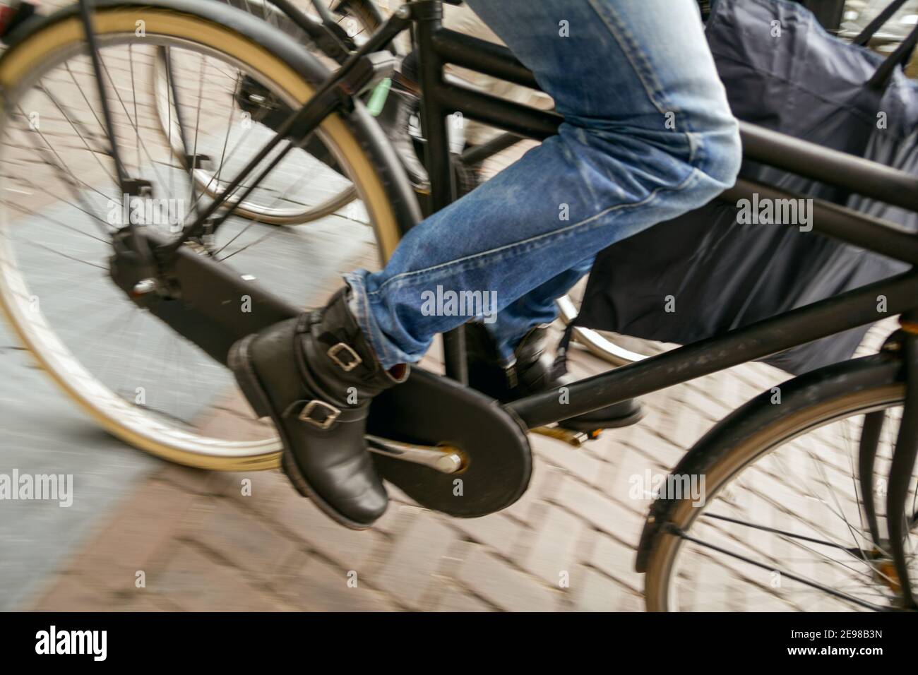 Dutch bicycle driver in Amsterdam/ Netherlands cycling with motion blur ...