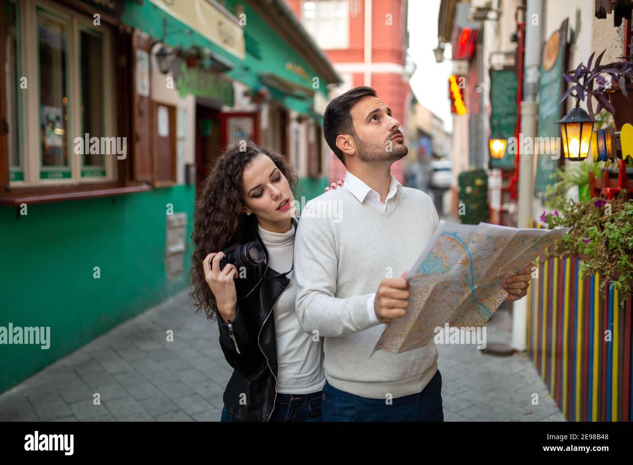Happy couple tourists sightseeing city with map. People, travel concept ...