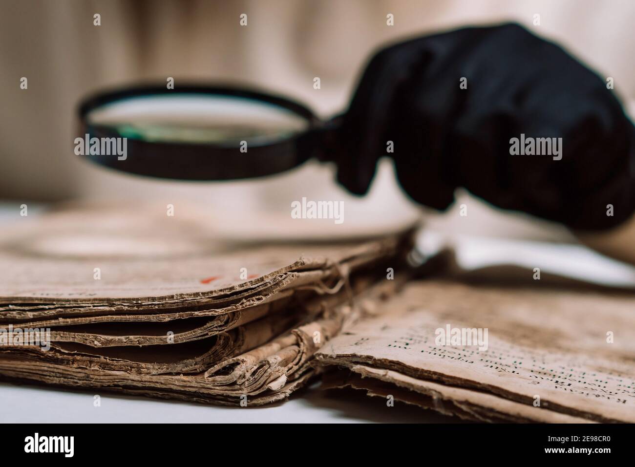Historian scientist in gloves reading antique book with magnifying ...