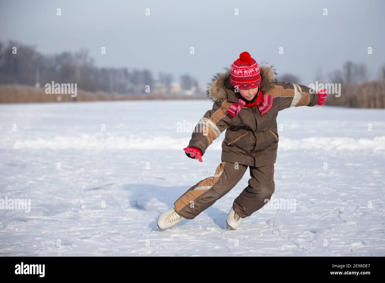 Child on ice in winter. The boy is skating on the ice lake Stock Photo ...