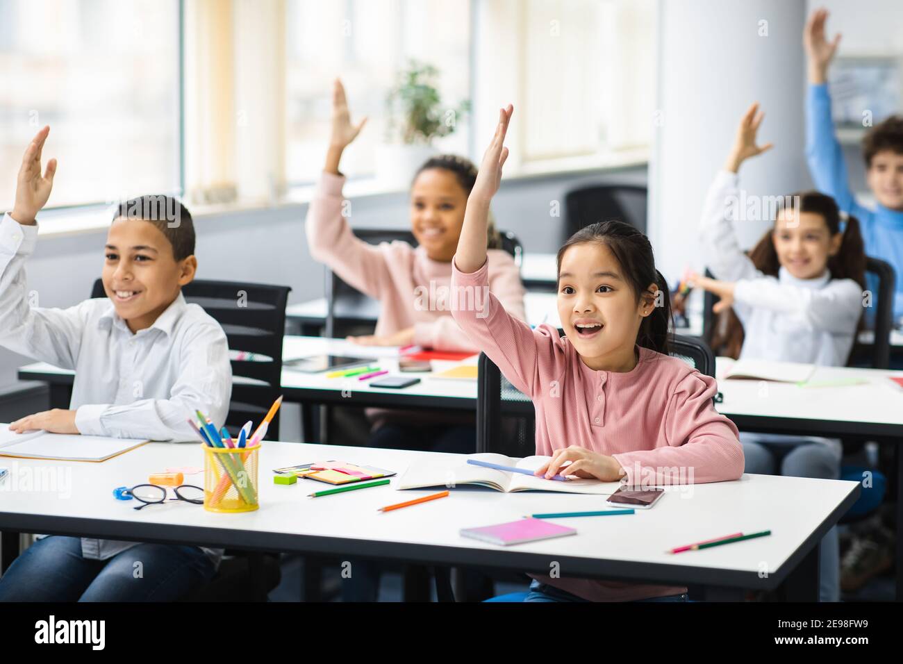 Kids raising hands classroom hi-res stock photography and images - Alamy