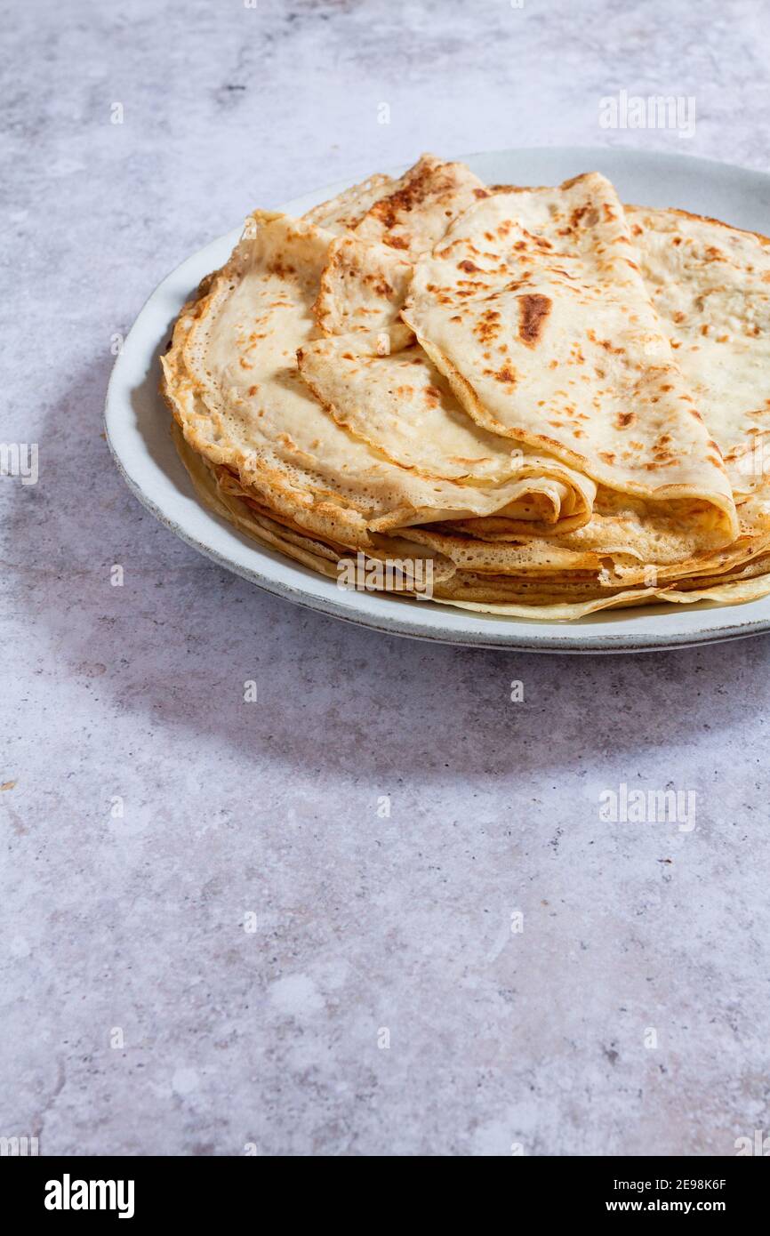 Stack of fresh French crepes (also known as pancakes) on a large plate ...
