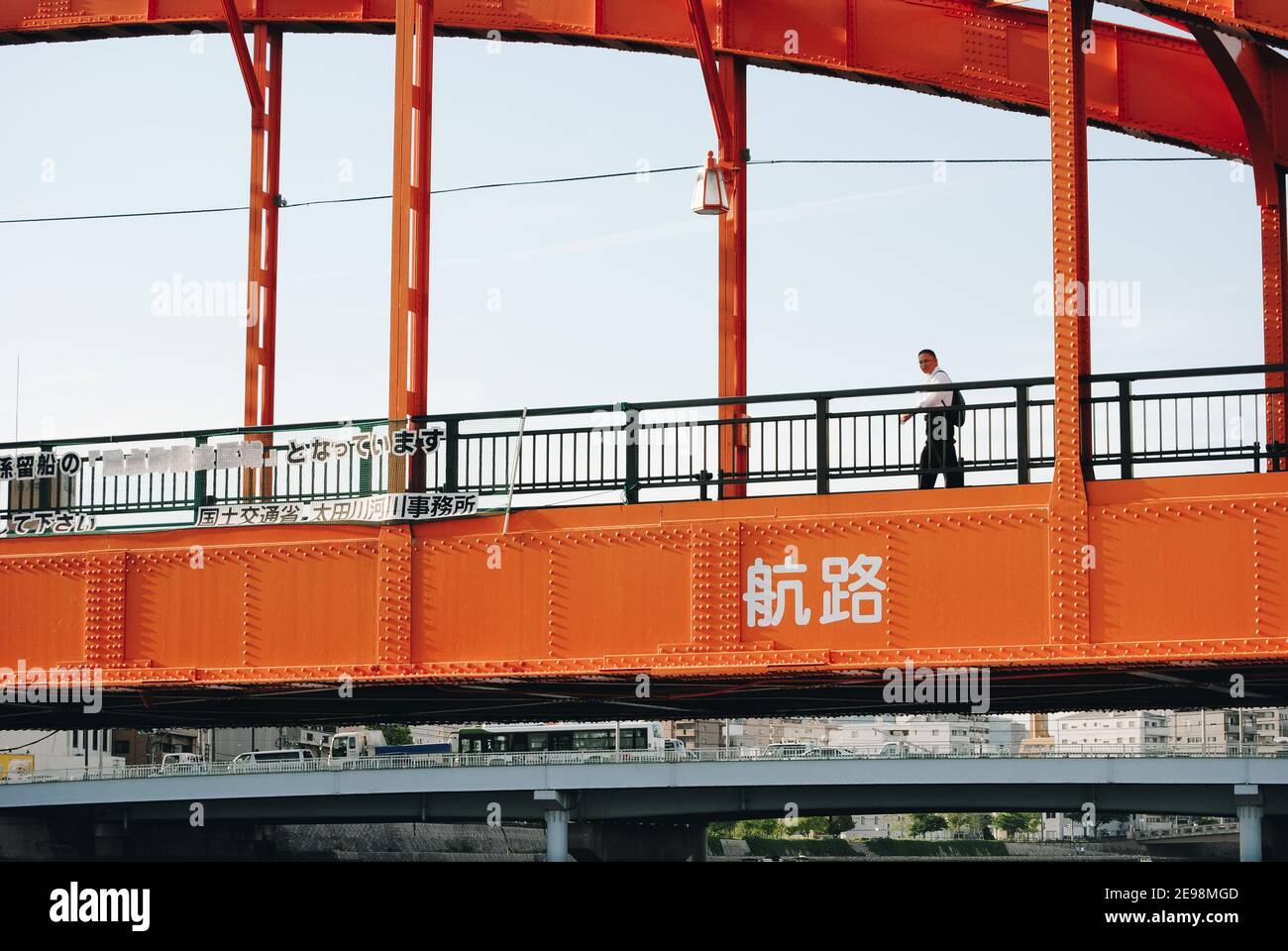 Man crossing an orange bridge Stock Photo - Alamy