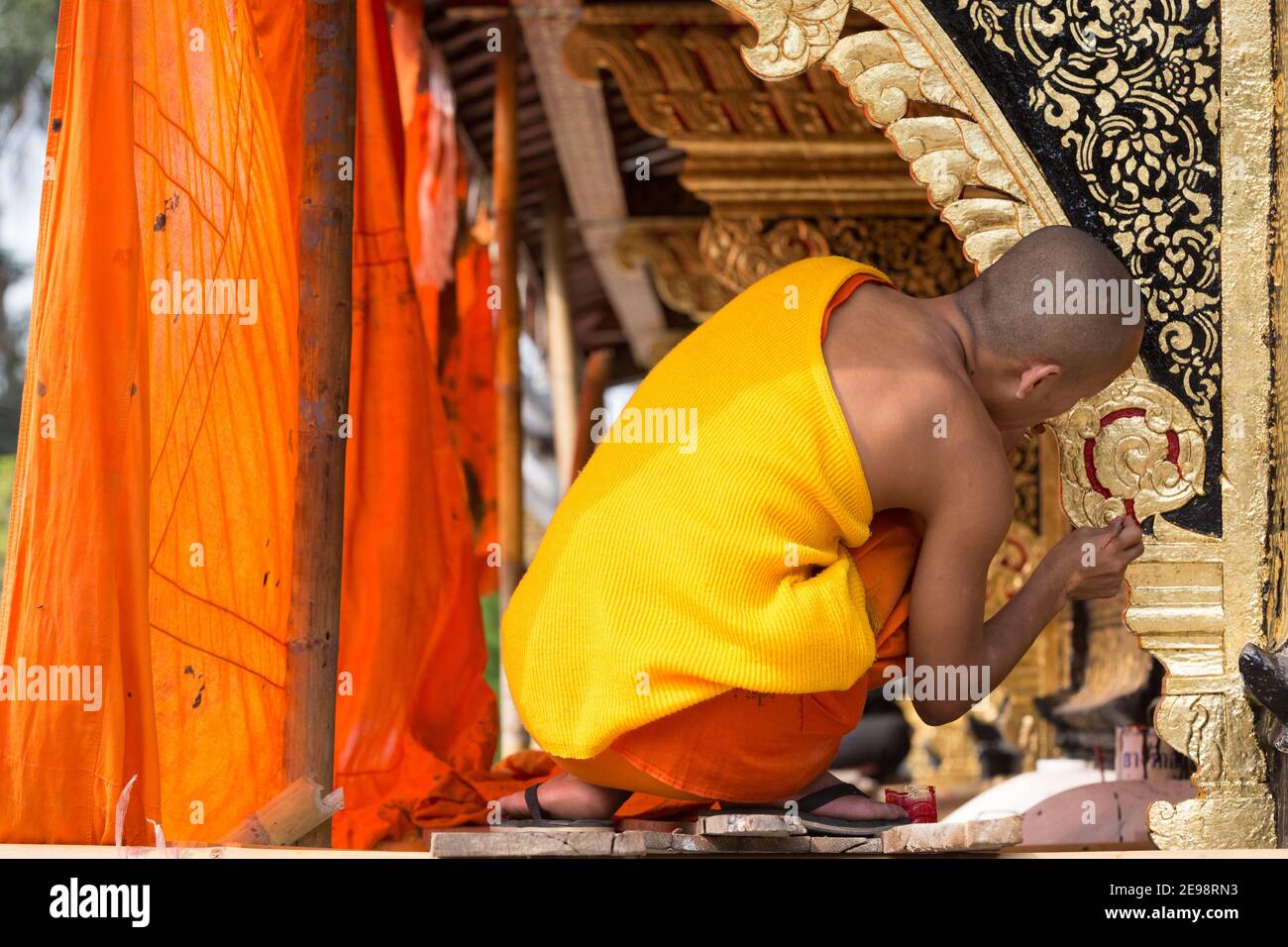Luang Prabang, Laos Monk restoring Wat Xieng Thong Stock Photo - Alamy