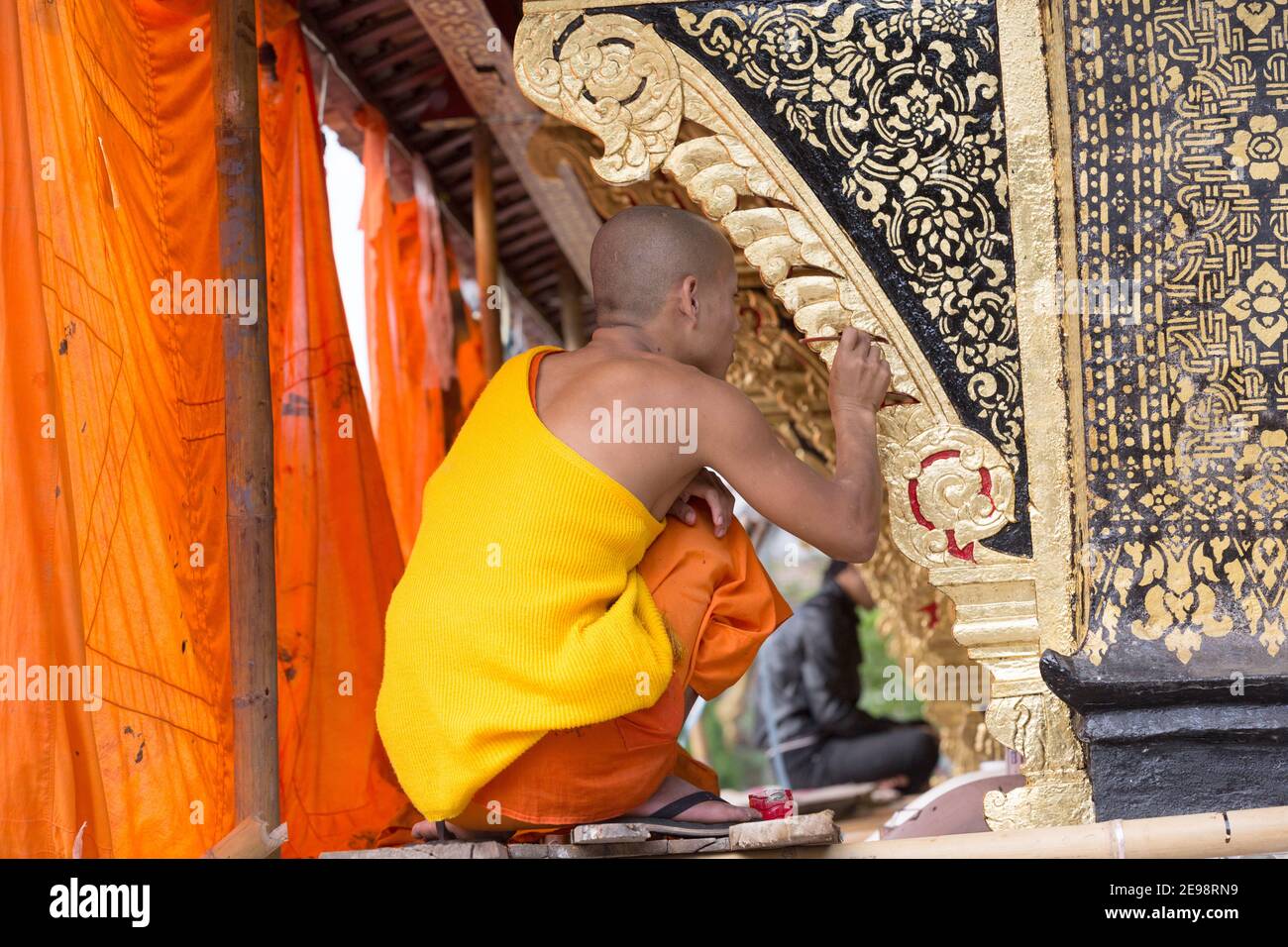 Luang Prabang, Laos Monk restoring Wat Xieng Thong Stock Photo - Alamy