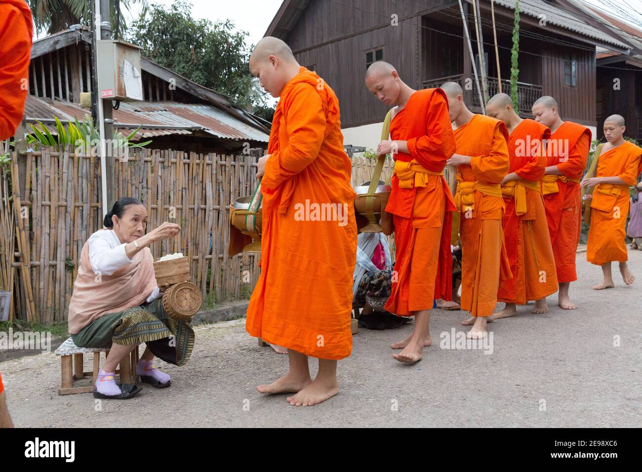 Woman giving alms monks hi-res stock photography and images - Alamy