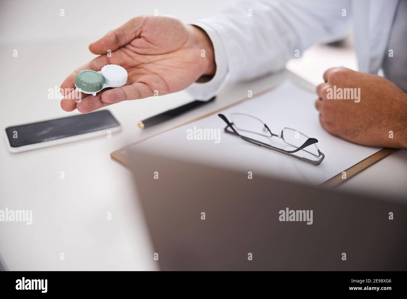 Optician in a lab coat demonstrating the contacts Stock Photo - Alamy