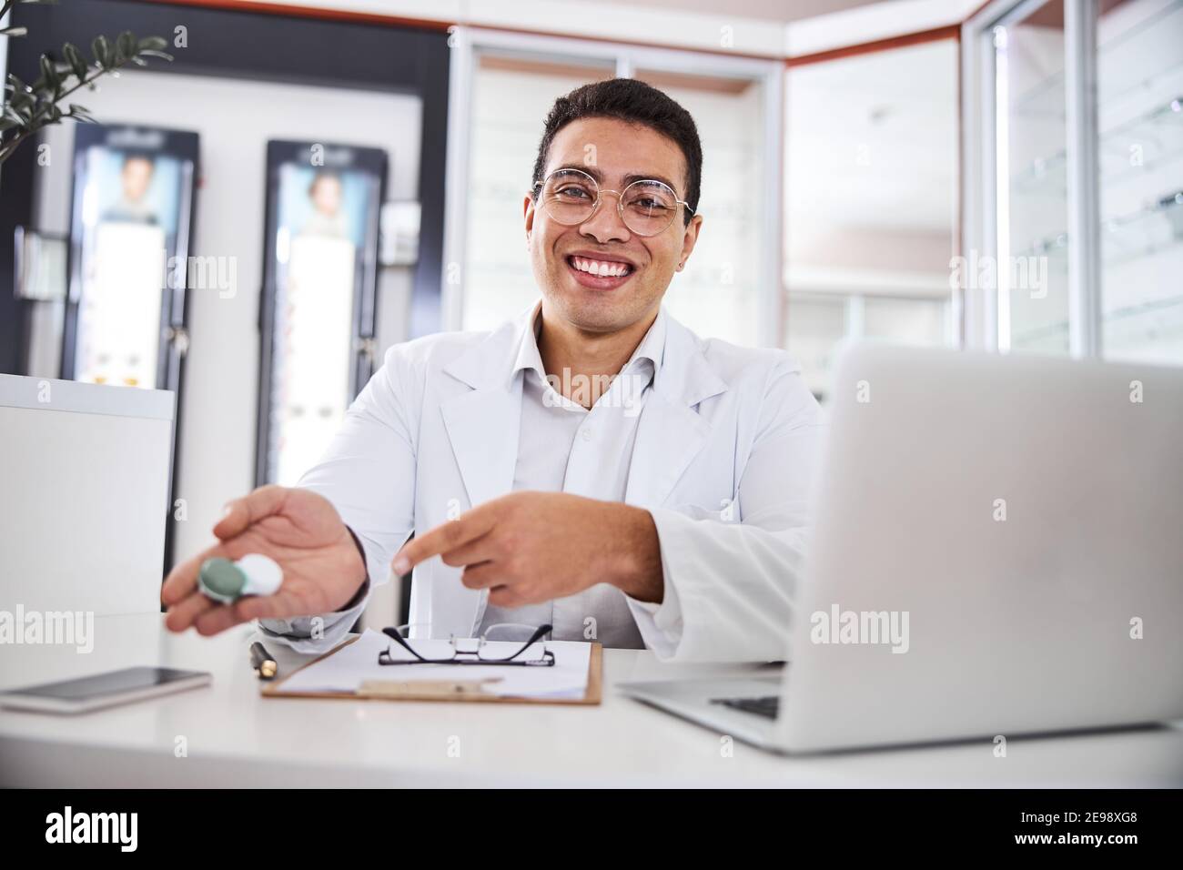 Merry optical dispenser in a lab coat demonstrating contacts Stock ...
