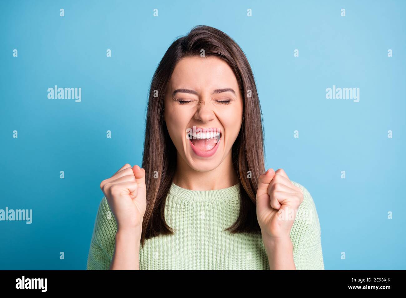 Photo of cute young lady raise arms open mouth closed eyes yell wear ...