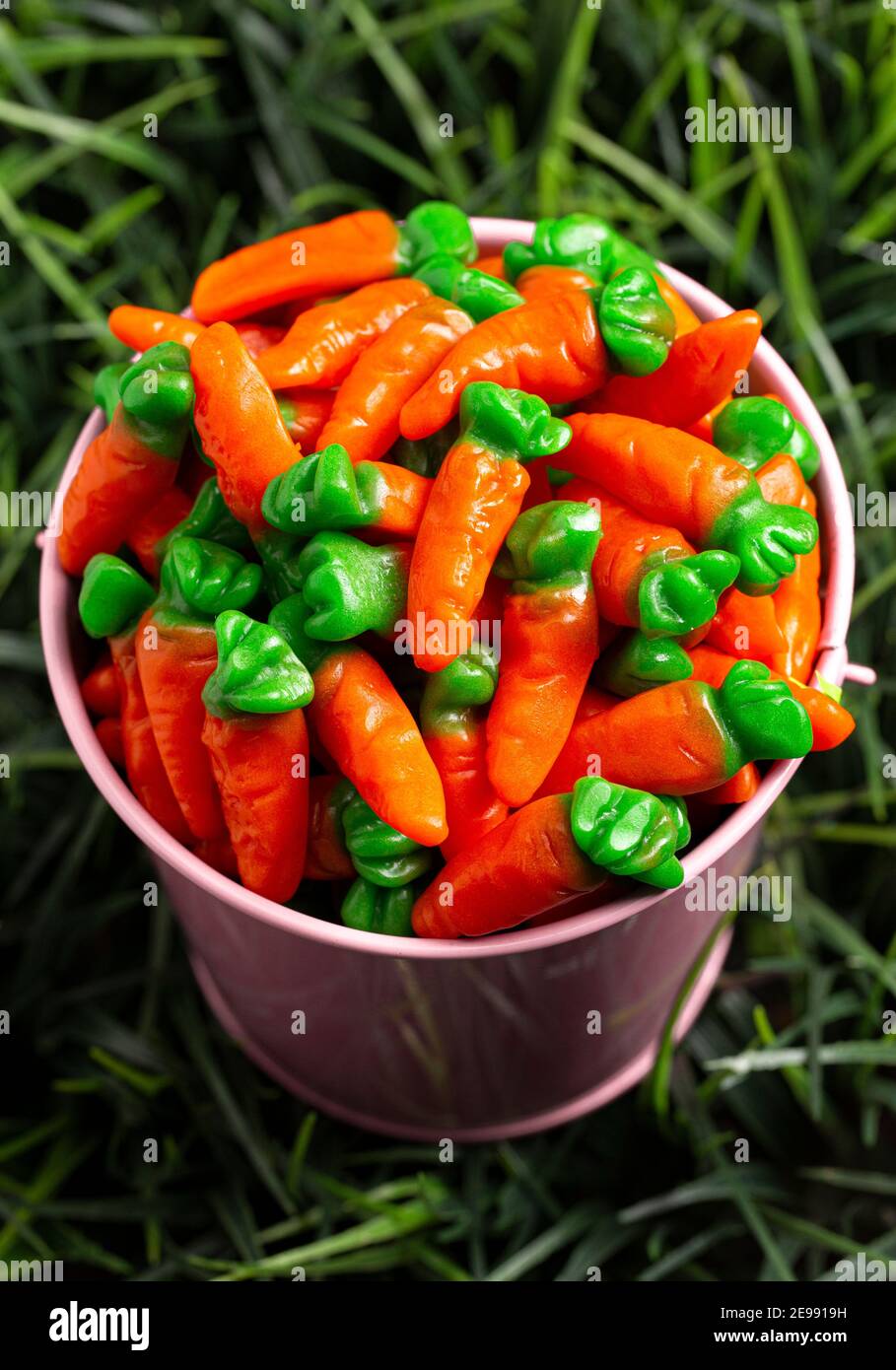 Gummy Candy Carrots in a Pink Bucket on the Grass Stock Photo - Alamy