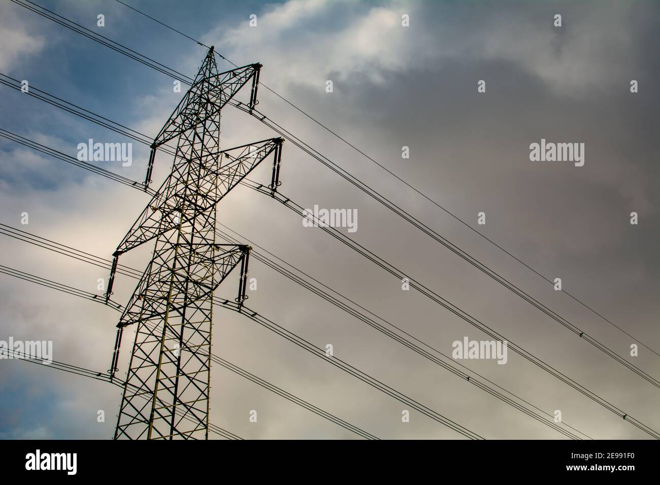 Electrical power mast in front of dark clouds as a concept of a ...