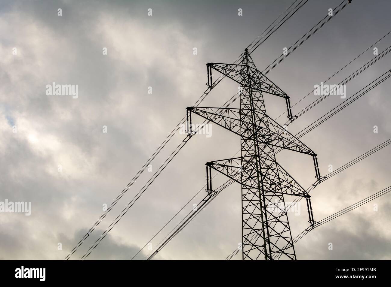 Electrical power mast in front of dark clouds as a concept of a ...