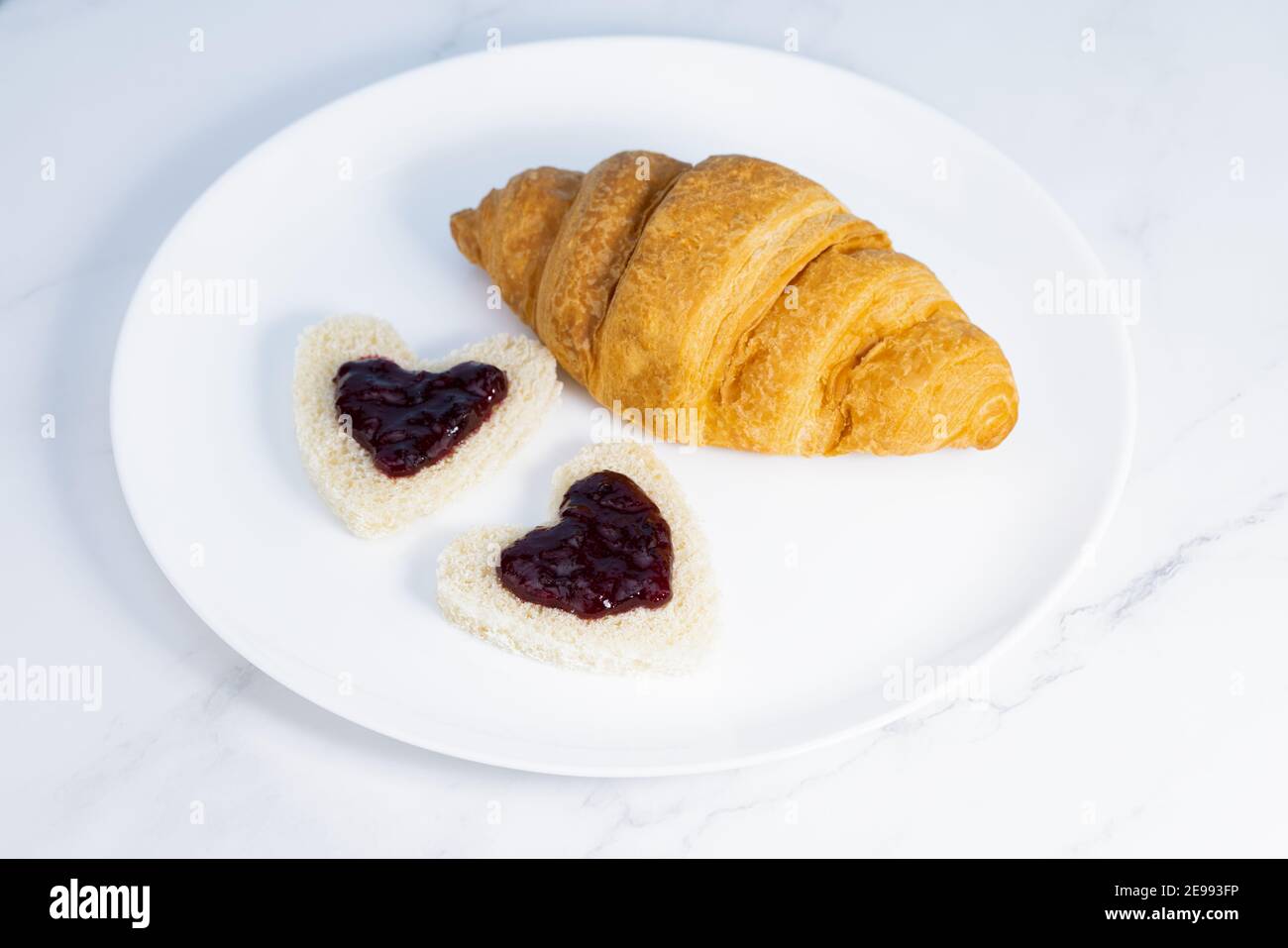 heart shaped croissant and toast with jam on light background ...