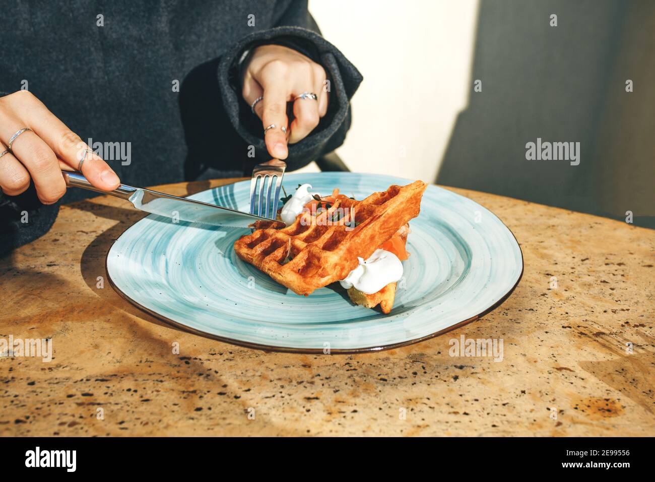 Close-up. Woman eats Belgian waffles for breakfast Stock Photo - Alamy