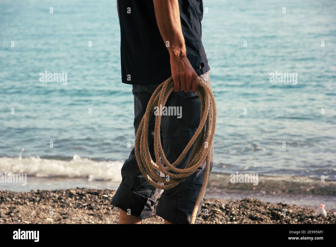 man on the beach holds a rope in his hand Stock Photo - Alamy