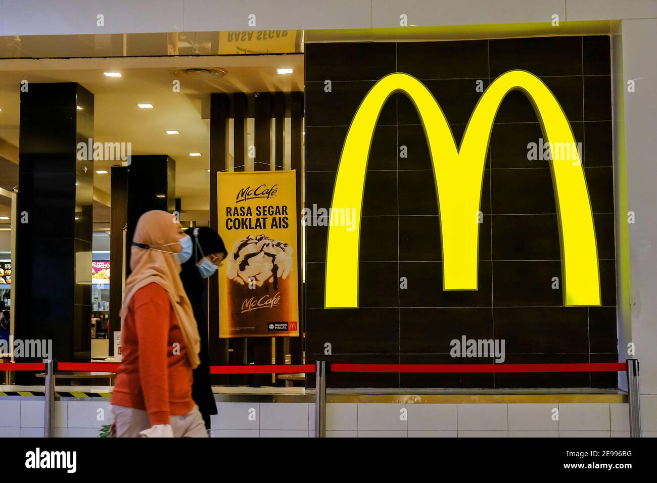 A lady wearing a face mask walks past the McDonald's restaurant. (Photo ...