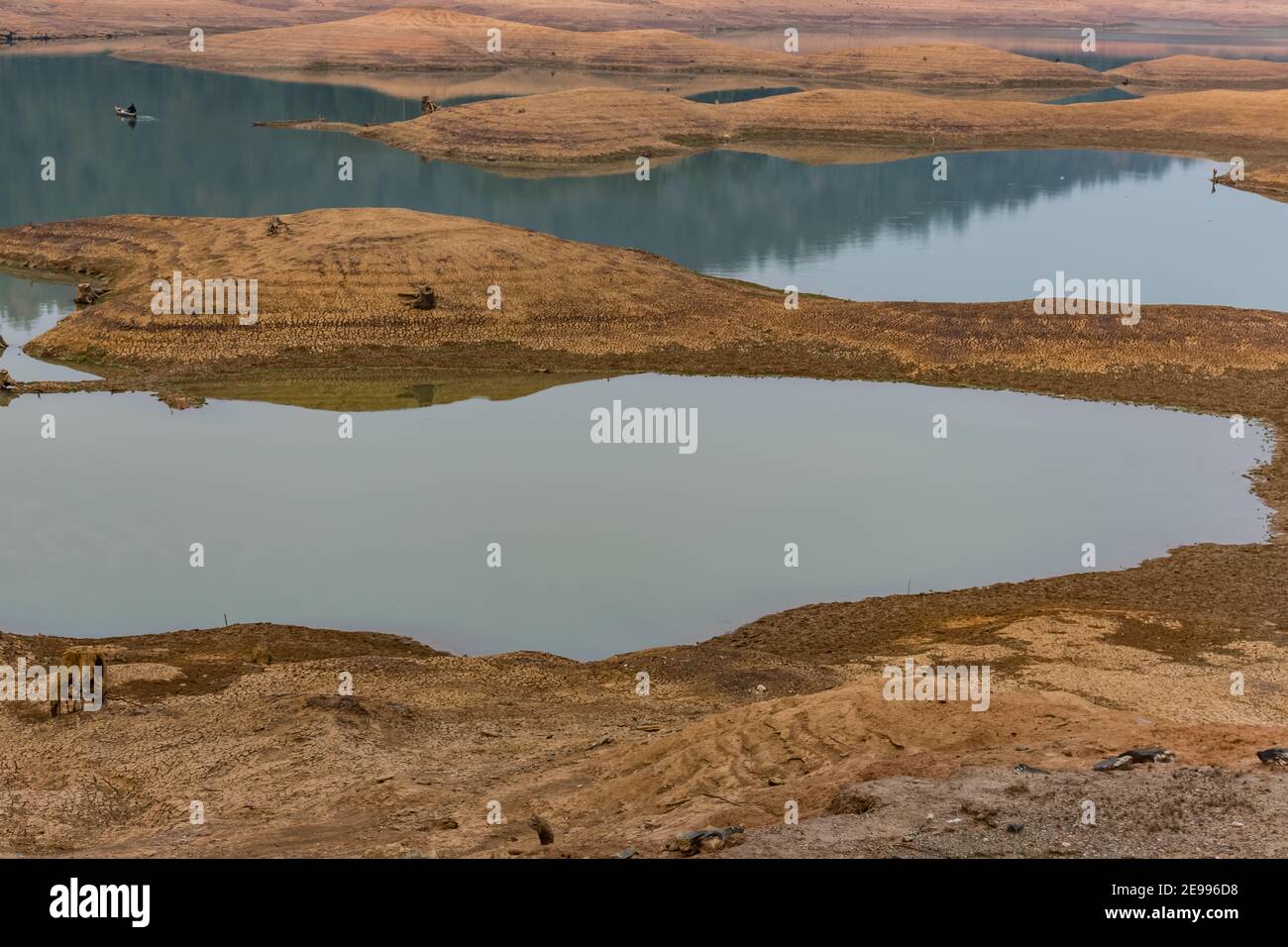 An rural indian small lake have very less water with greenery mountain ...