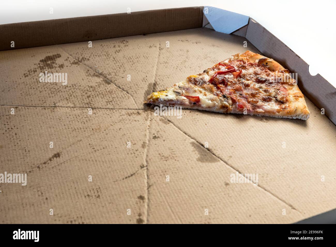 Last slice of pizza in a delivery cardboard box. Concept for home ...