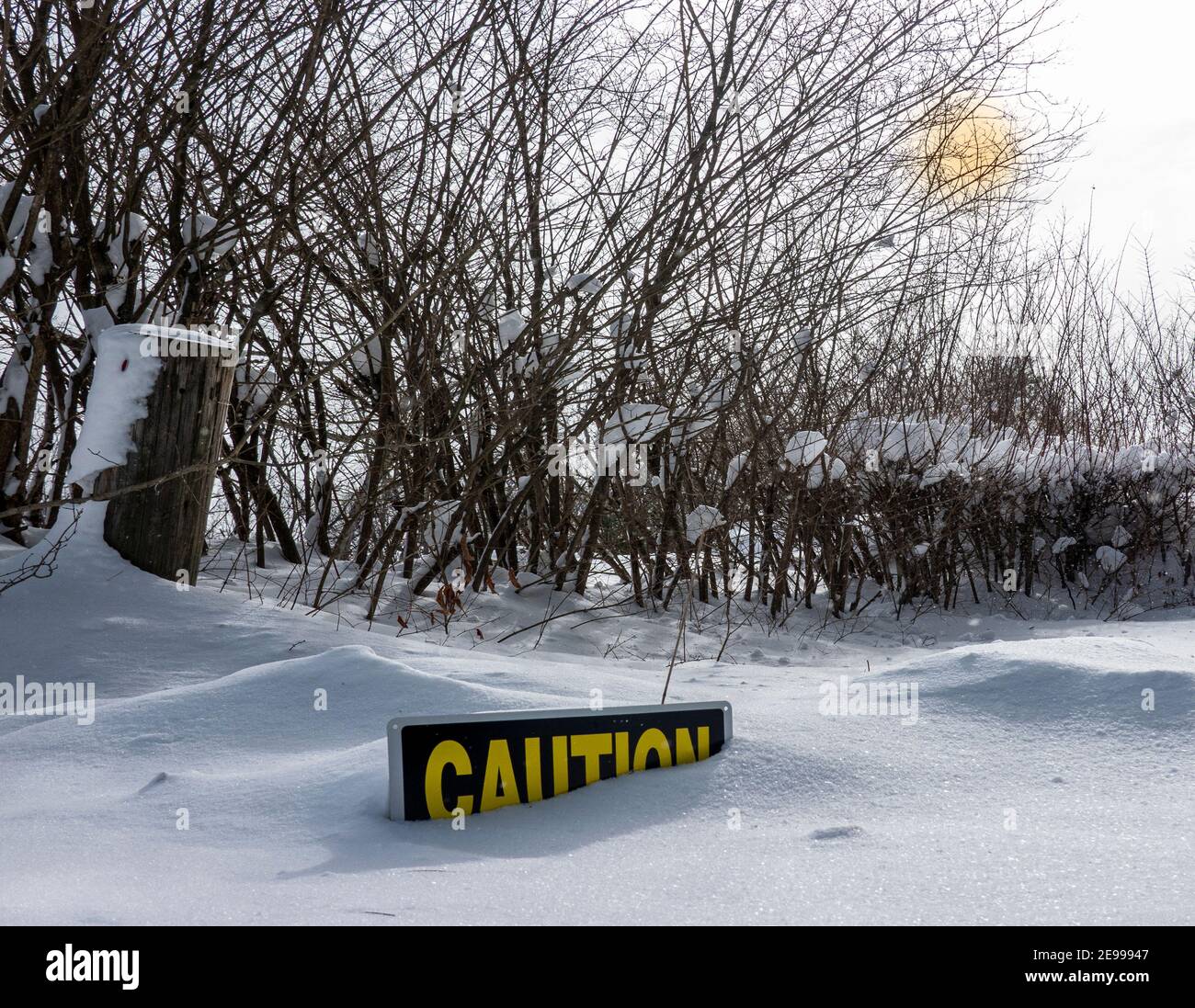 caution sign buried in snow with drift Stock Photo - Alamy
