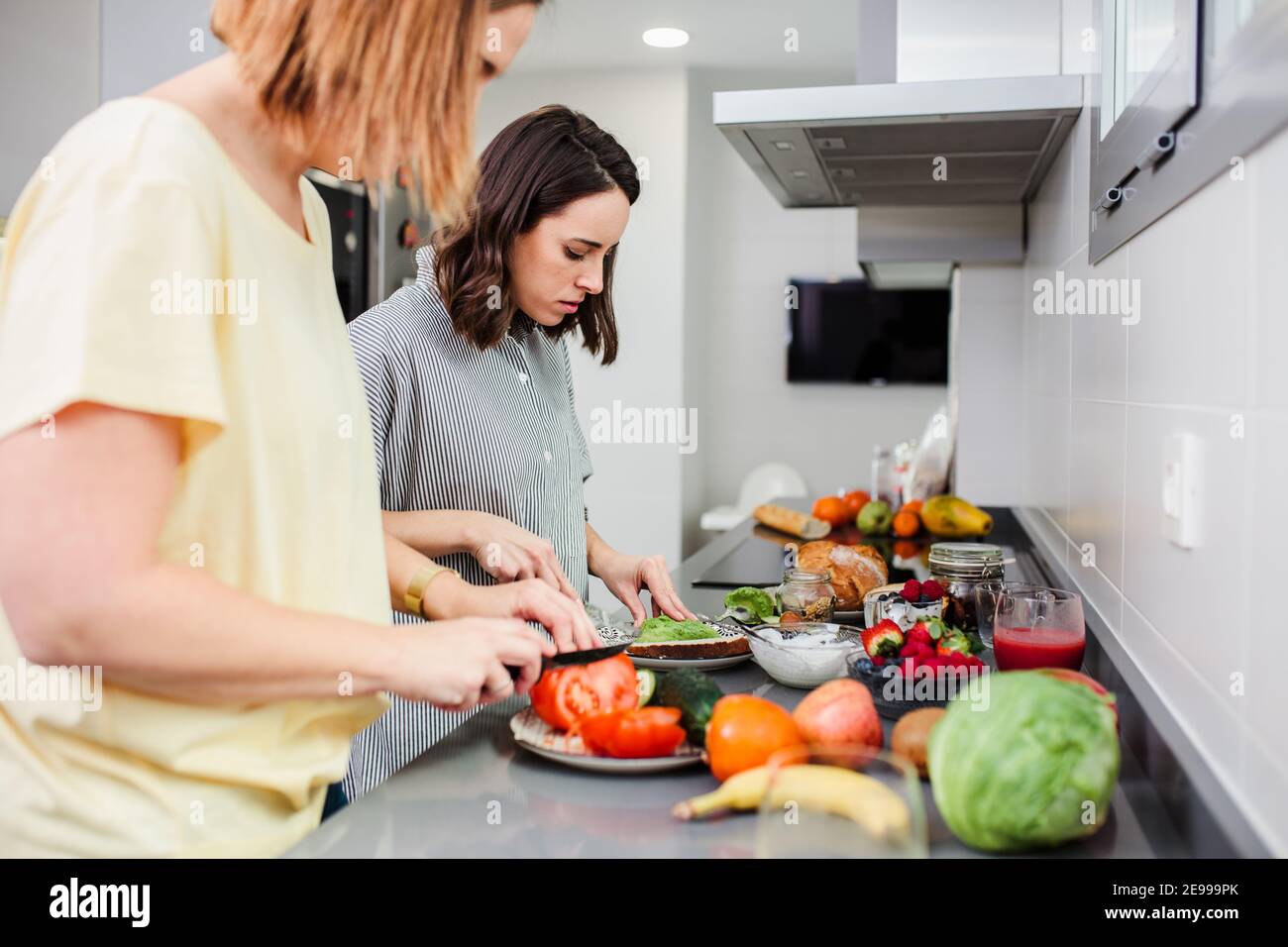 Two women preparing healthy food on the kitchen counter, diet and ...
