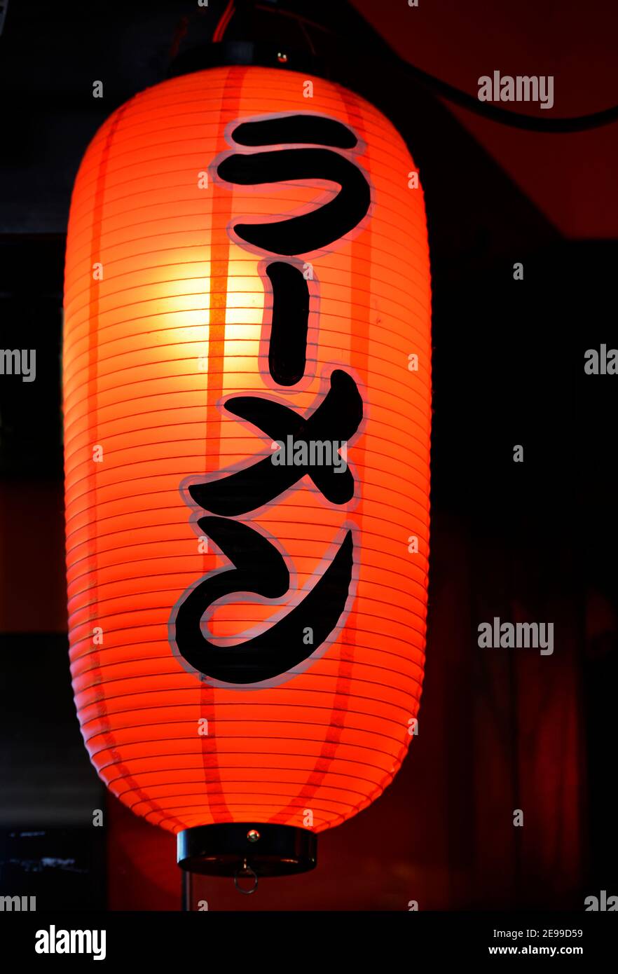 A red Japanese lantern advertising ramen noodles hangs outside a ...