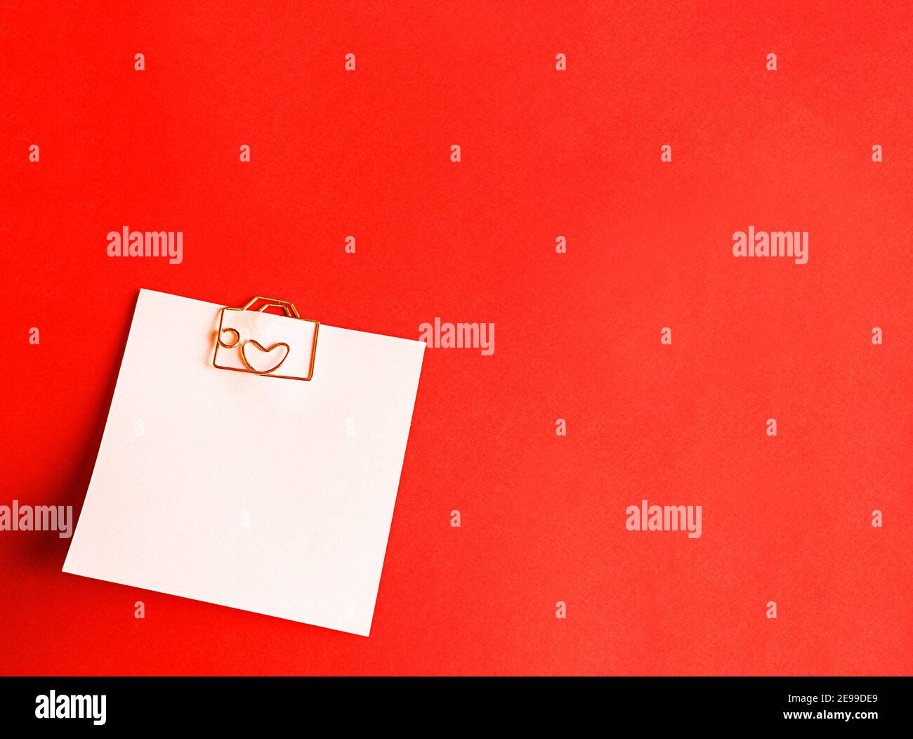 Square sheet for notes with a paper clip in shape of a letter and a ...