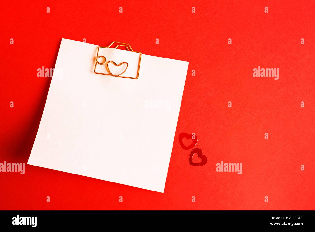Square sheet for notes with a paper clip in shape of a letter and a ...