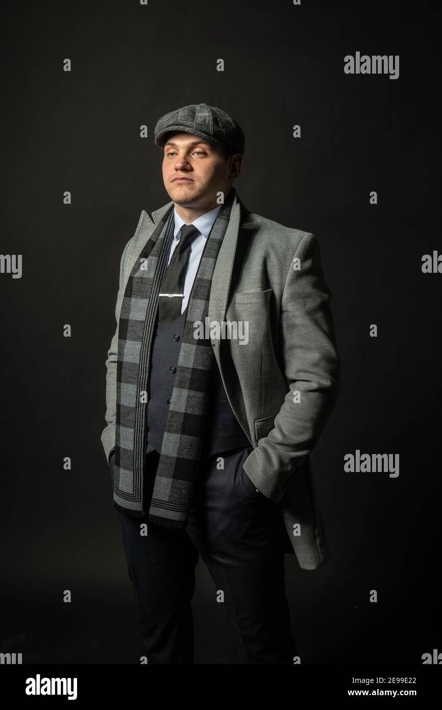 in a coat and a cap a scarf Young man three piece suit business model ...