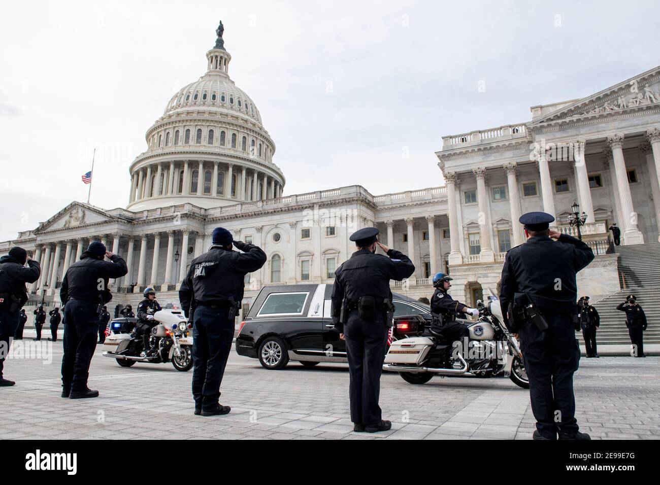 U.S. Capitol Police salute as a hearse carrying an urn with the ...