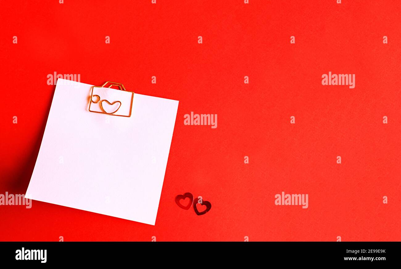 Square sheet for notes with a paper clip in shape of a letter and a ...