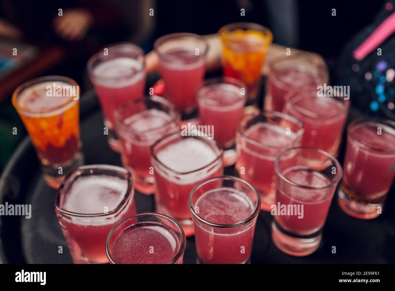 Variation of hard alcoholic shots served on bar counter. Blur bottles ...