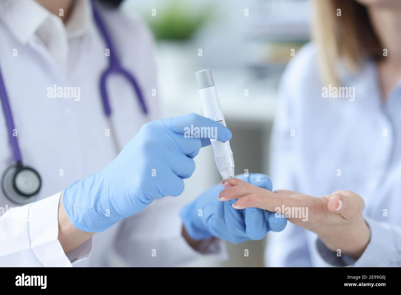 Nurse drawing blood from patient with lancet closeup Stock Photo - Alamy