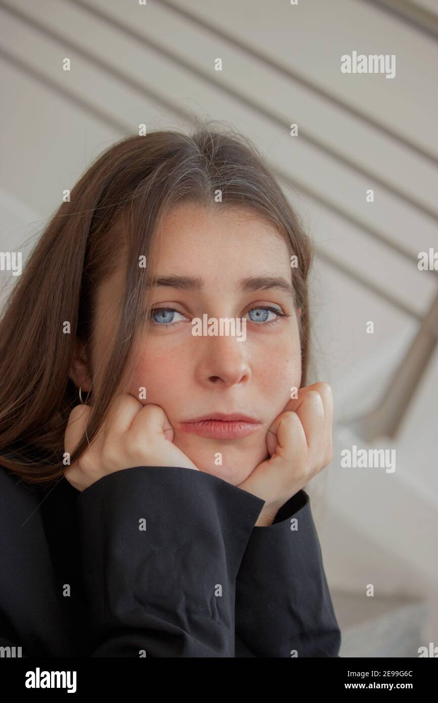 Portrait of a confident woman posing at camera with dark jacket and ...