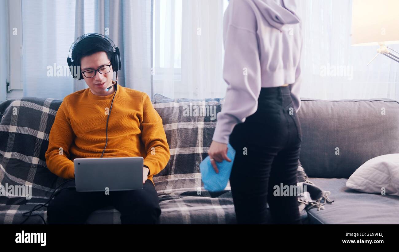 Young man playing games on his laptop and ignoring his girlfriend ...