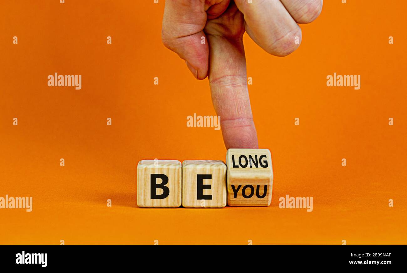 Be you, belong symbol. Businessman hand turns a cube and changes words ...