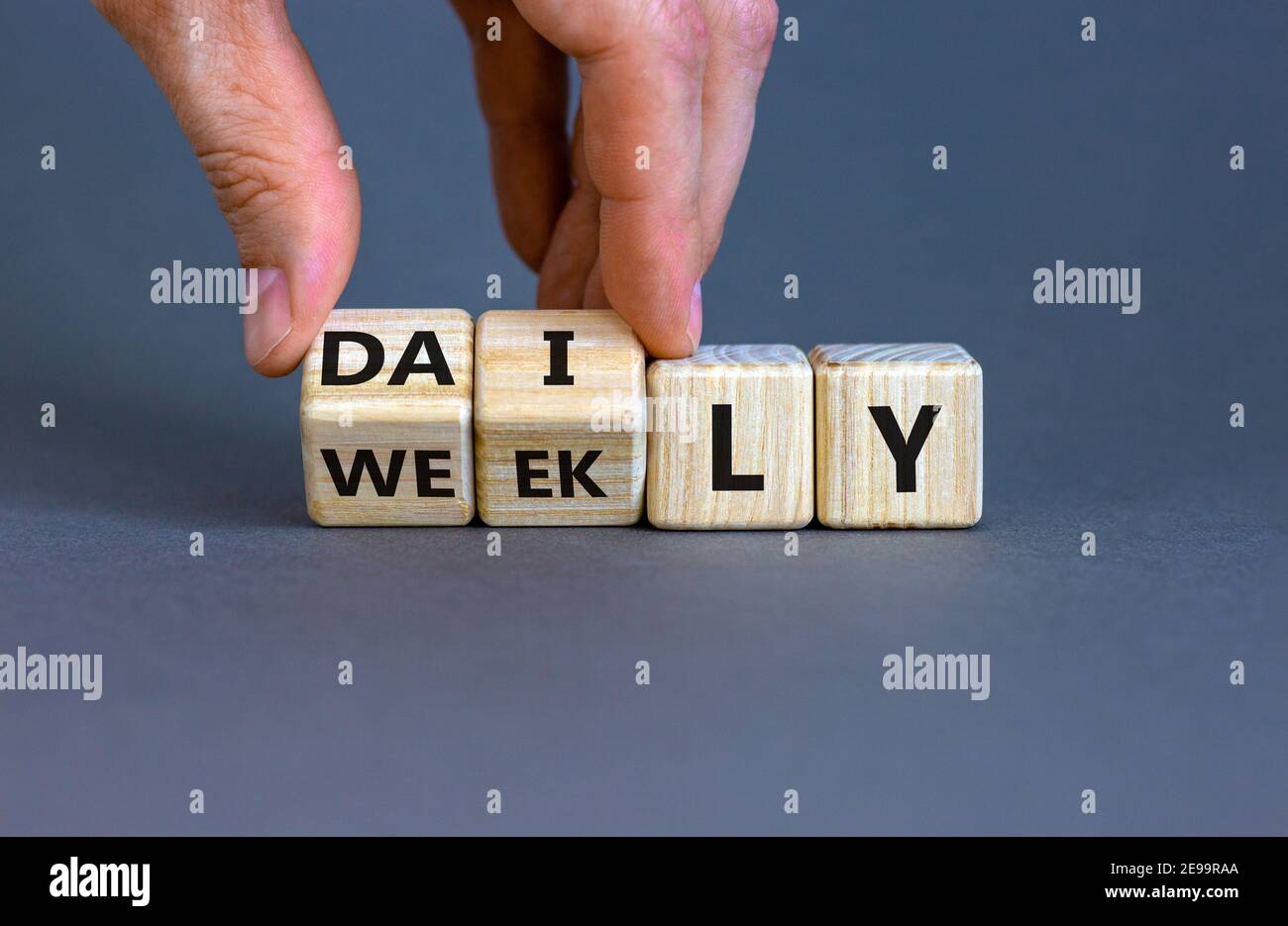 Daily or weekly symbol. Businessman flips wooden cubes and changes the ...