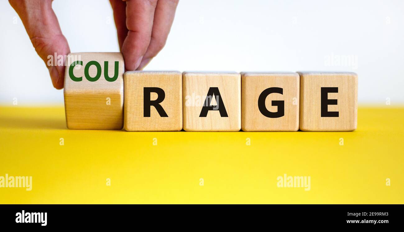 Rage or courage symbol. Businessman turns a cube and changes the word ...