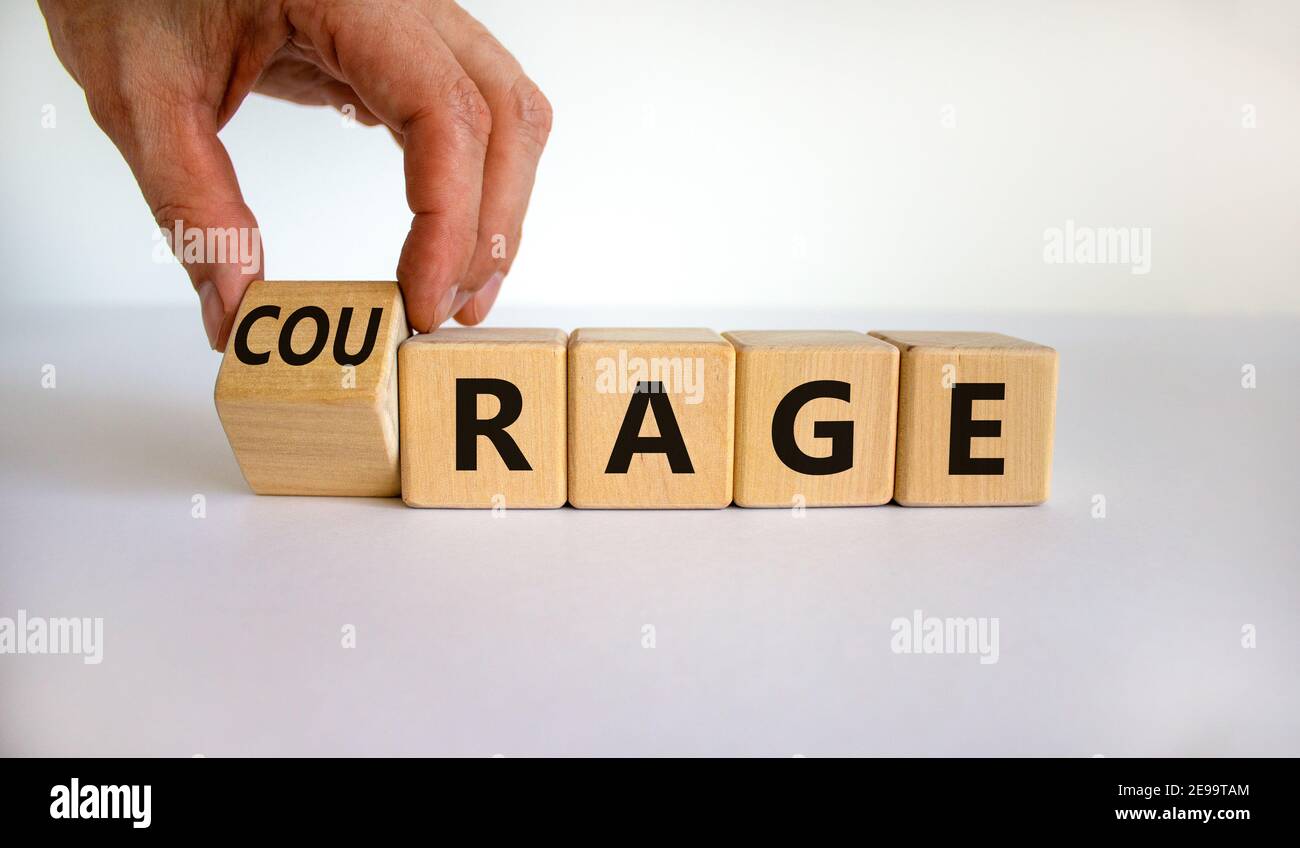 Rage or courage symbol. Businessman turns a cube and changes the word ...