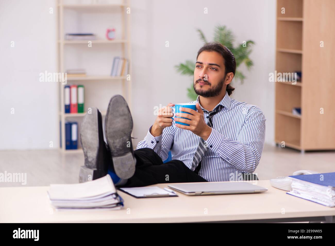 Young employee drinking coffee during break Stock Photo - Alamy