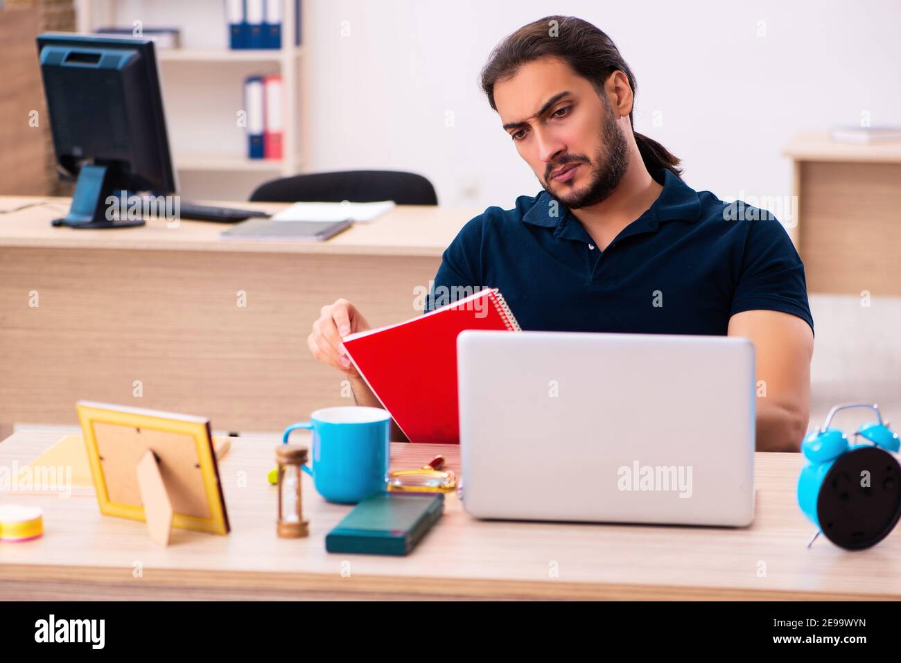 Young employee working at workplace Stock Photo - Alamy