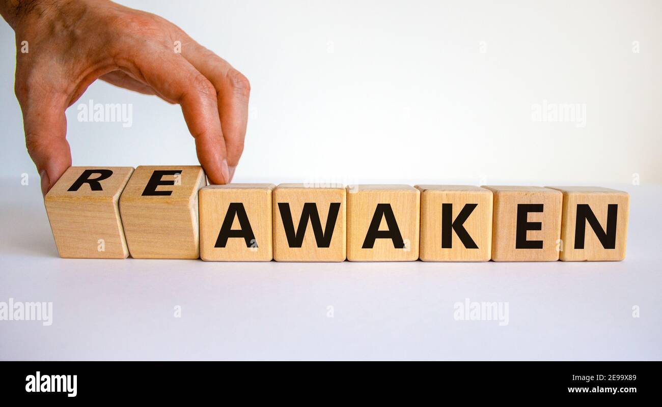 Reawaken symbol. Businessman turns cubes and changes the word 'awaken ...