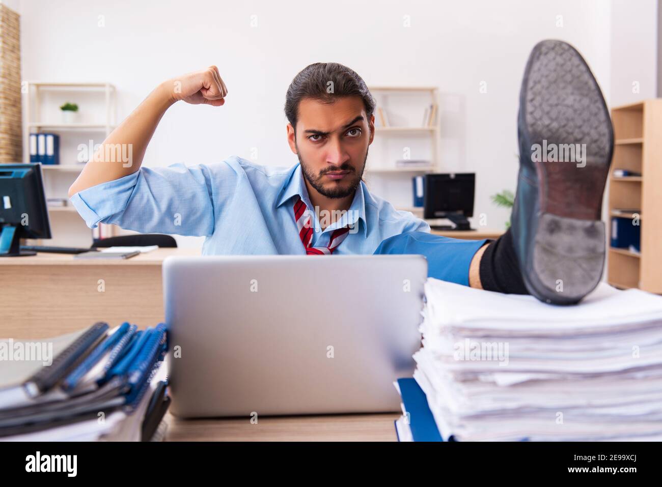 Young employee unhappy with excessive work in the office Stock Photo ...