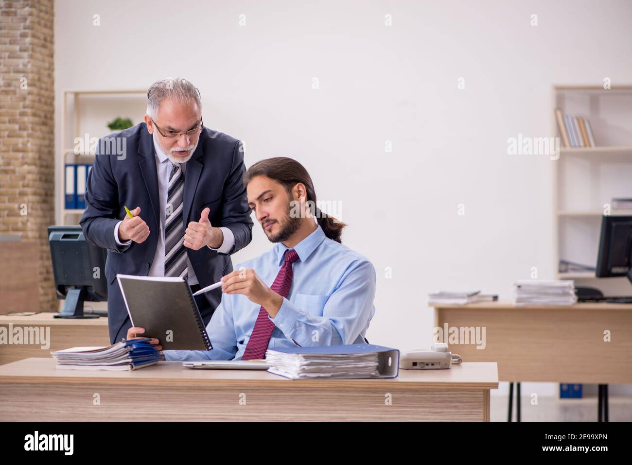 Old boss and young employee working in the office Stock Photo - Alamy