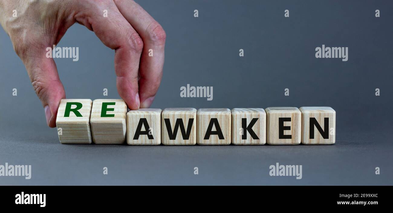 Reawaken symbol. Businessman turns cubes and changes the word 'awaken ...