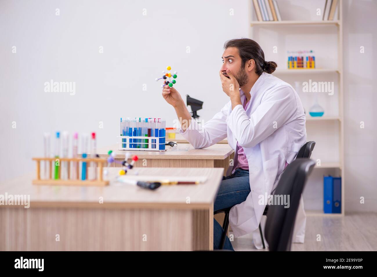 Young chemist sitting at the desk in the classroom Stock Photo - Alamy