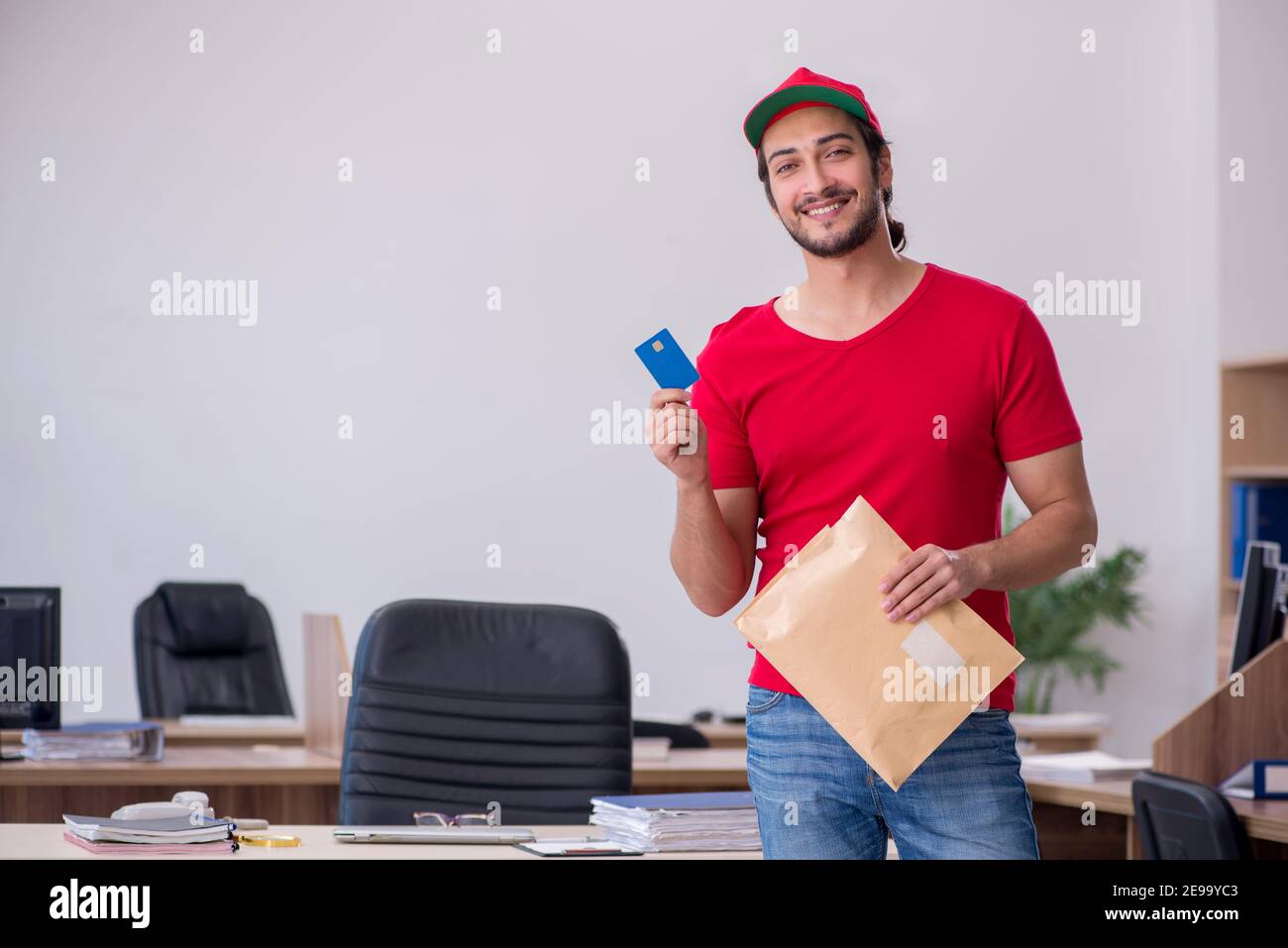 Young courier delivering post to the office Stock Photo - Alamy