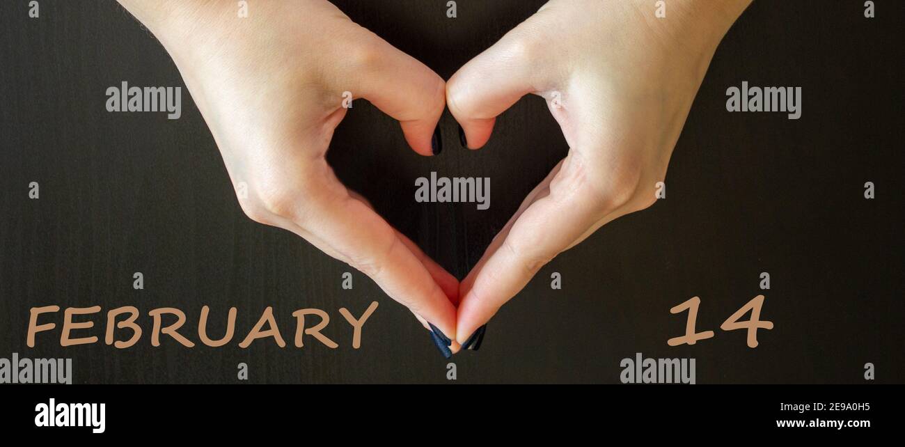 February 14 valentines day symbol. Woman making heart shape on dark ...